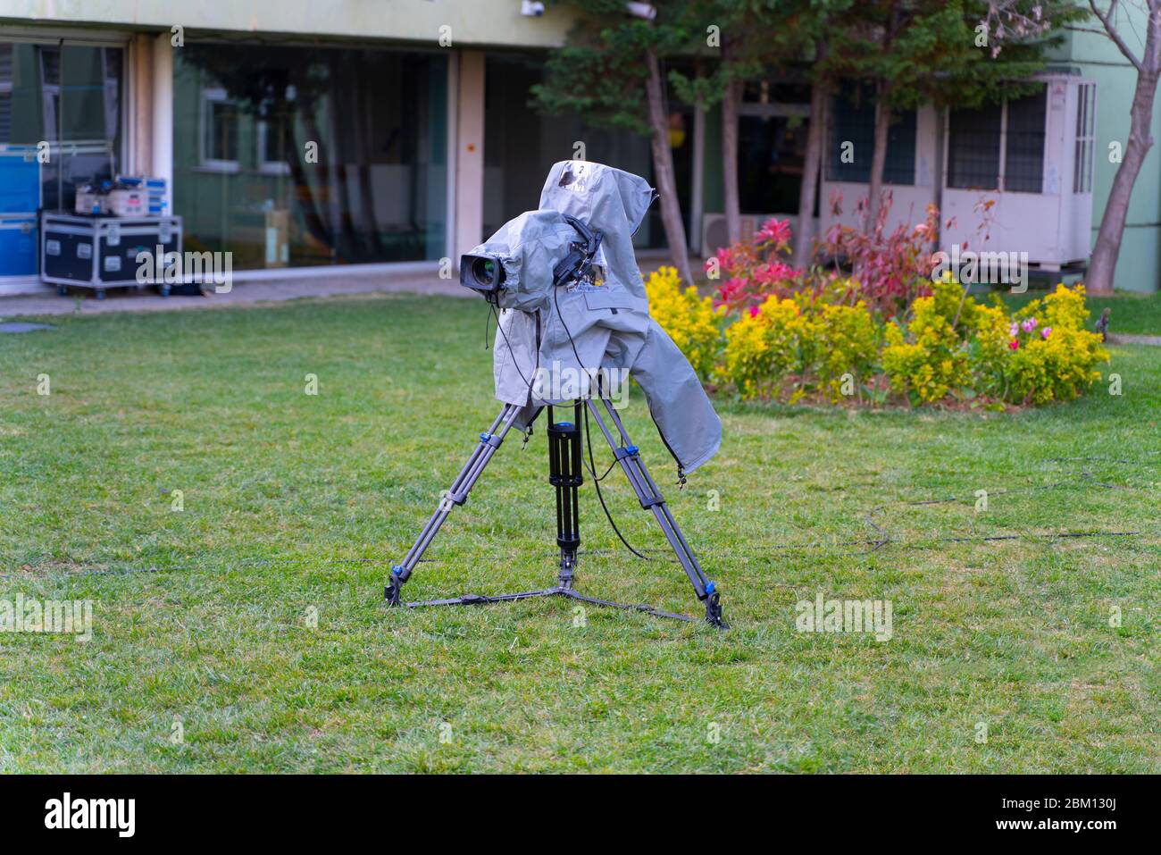 Television broadcast camera setup on a tripod and protected by a rain ...