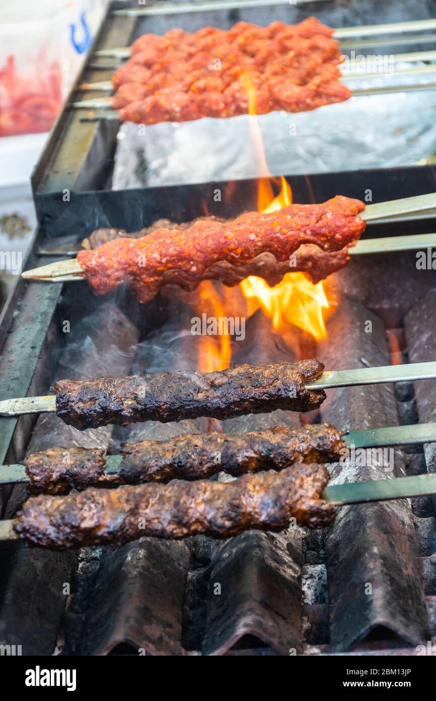 Adana kebab (ground lamb minced meat on skewer on grill over charcoal ...