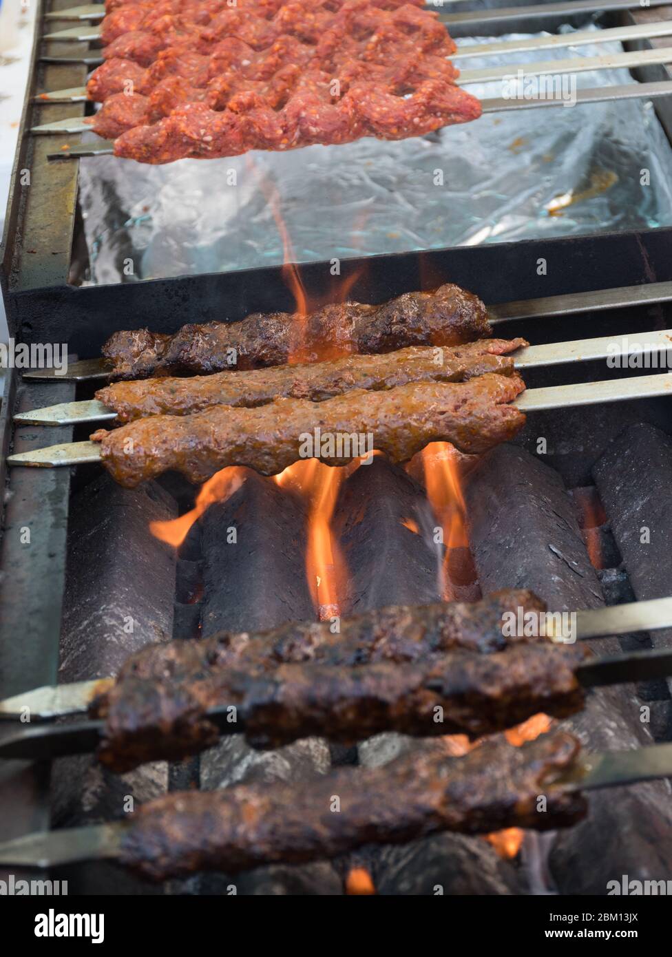 Adana kebab (ground lamb minced meat on skewer on grill over charcoal ...