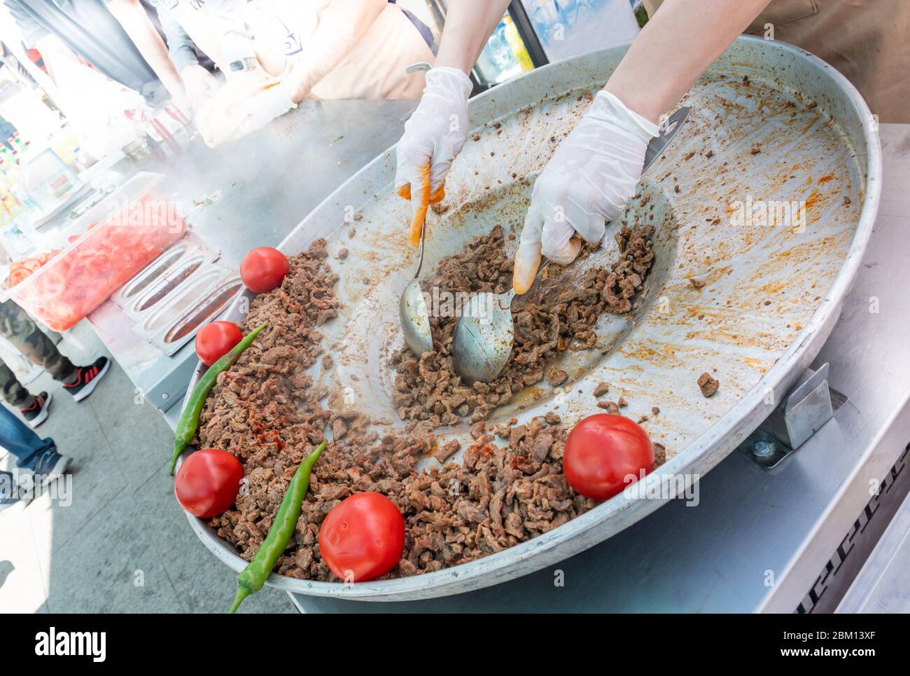 Traditional Turkish shawarma meat being prepared with red tomatoes and ...