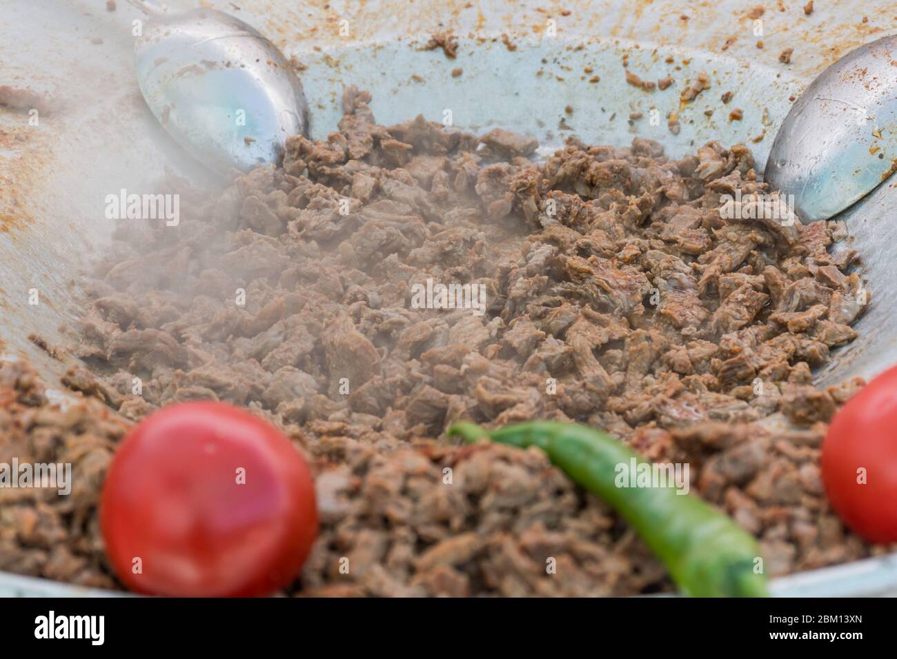 Traditional Turkish shawarma meat being prepared with red tomatoes and ...
