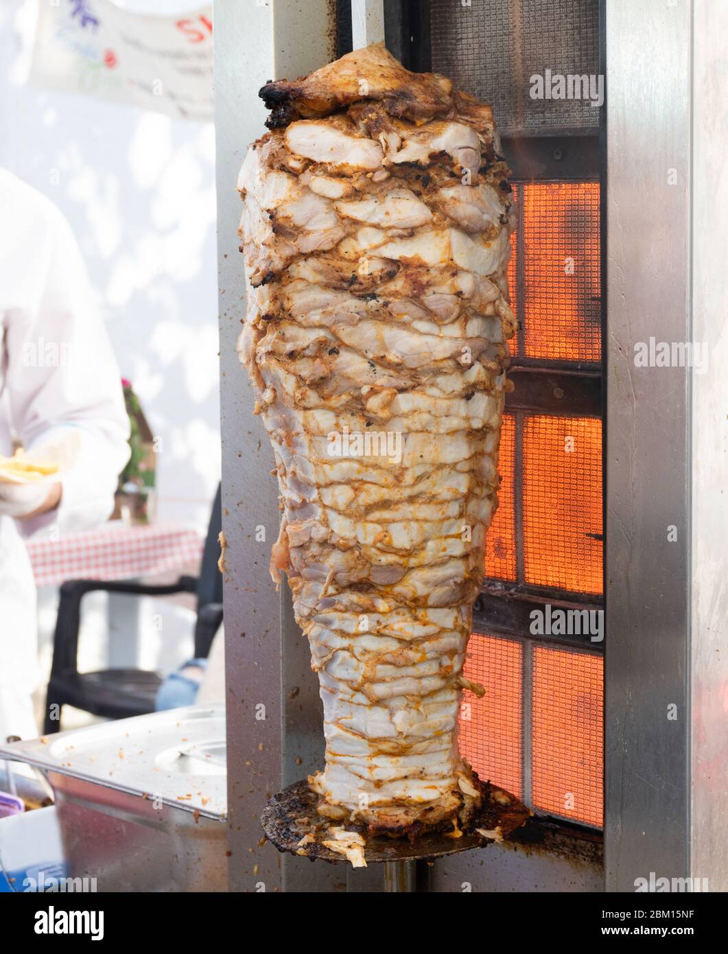 Turkish shawarma roasting on vertical skewer Grilled skewered chicken ...
