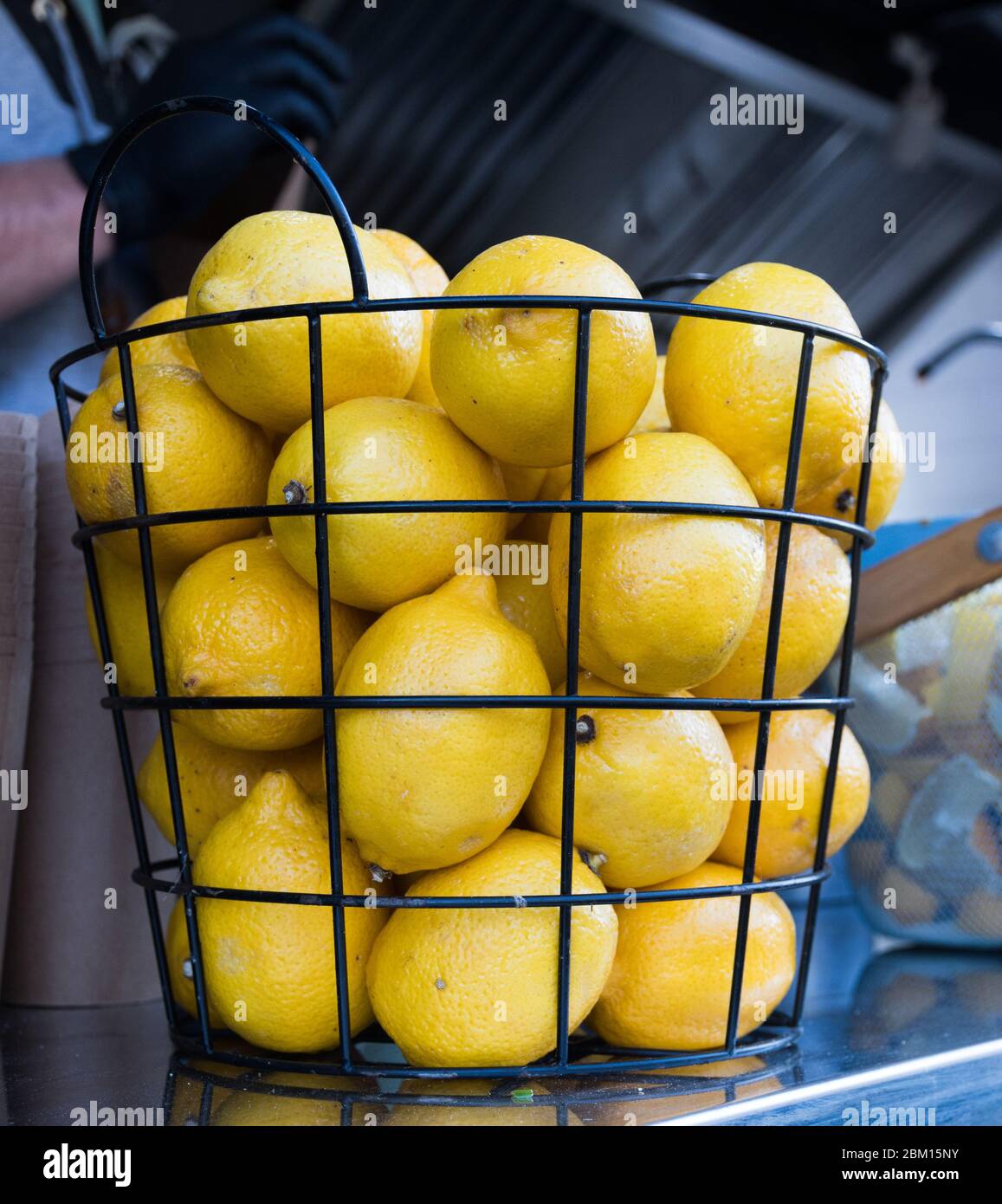 Yellow lemons in a metal basket during street food festival. Lemonade ...