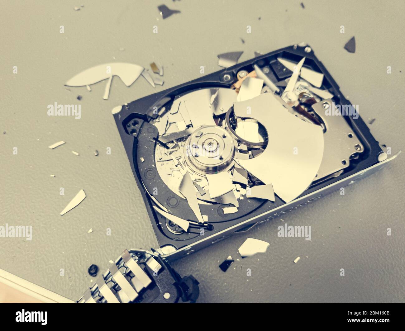 Broken computer hard disk on a table - complete data destruction Stock ...