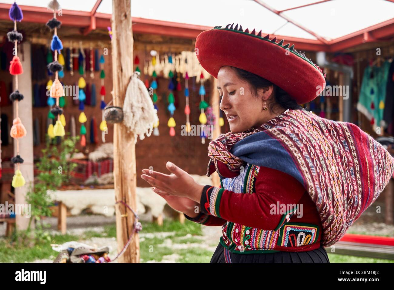 Inca girl demonstrating fabric dyes in small crafts market in rural ...