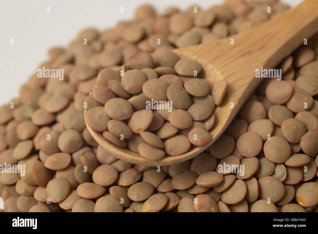 Pile of raw lentil in a spoon isolated on white background Stock Photo - Alamy