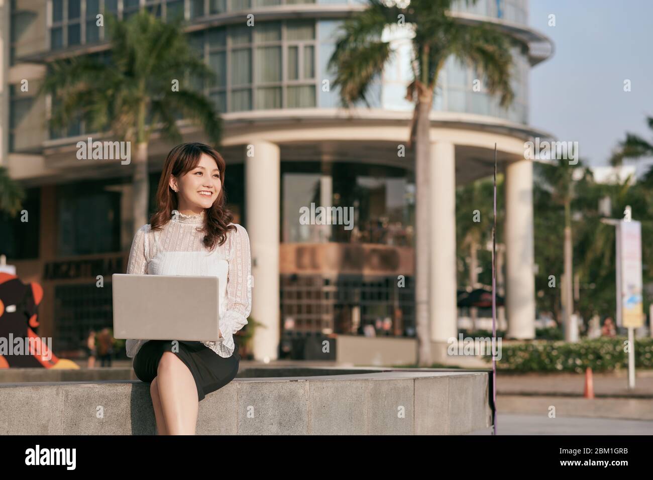 Young woman using laptop computer and smartphone. Beautiful student ...