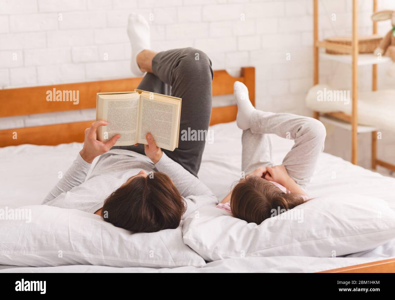 Father and daughter reading book together on weekend Stock Photo - Alamy