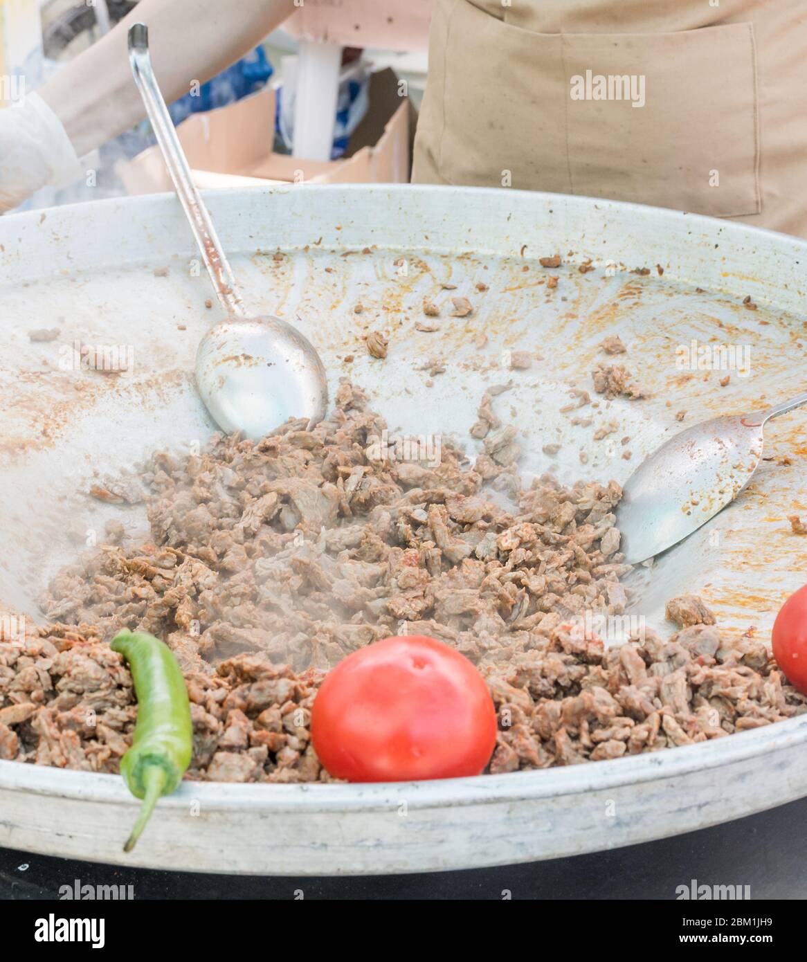 Traditional Turkish shawarma meat being prepared with red tomatoes and ...