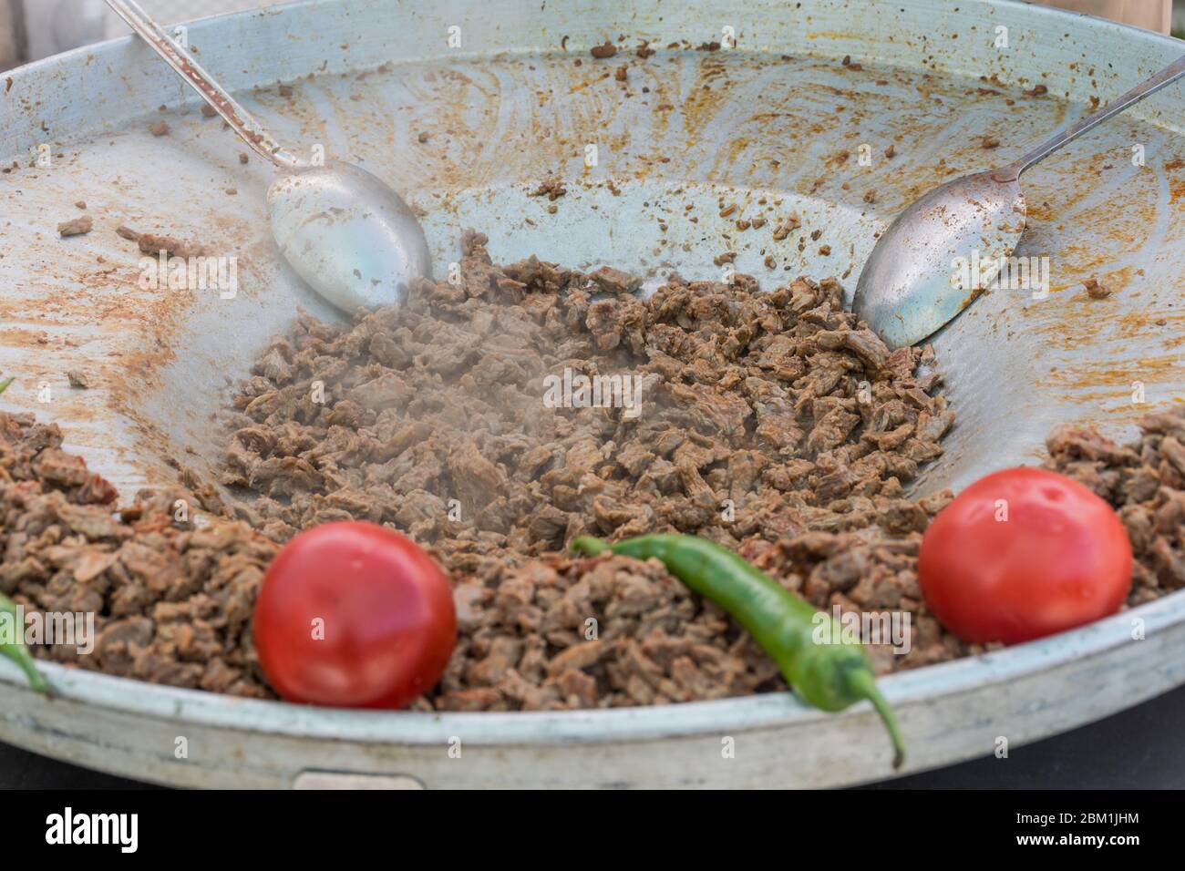 Traditional Turkish shawarma meat being prepared with red tomatoes and ...