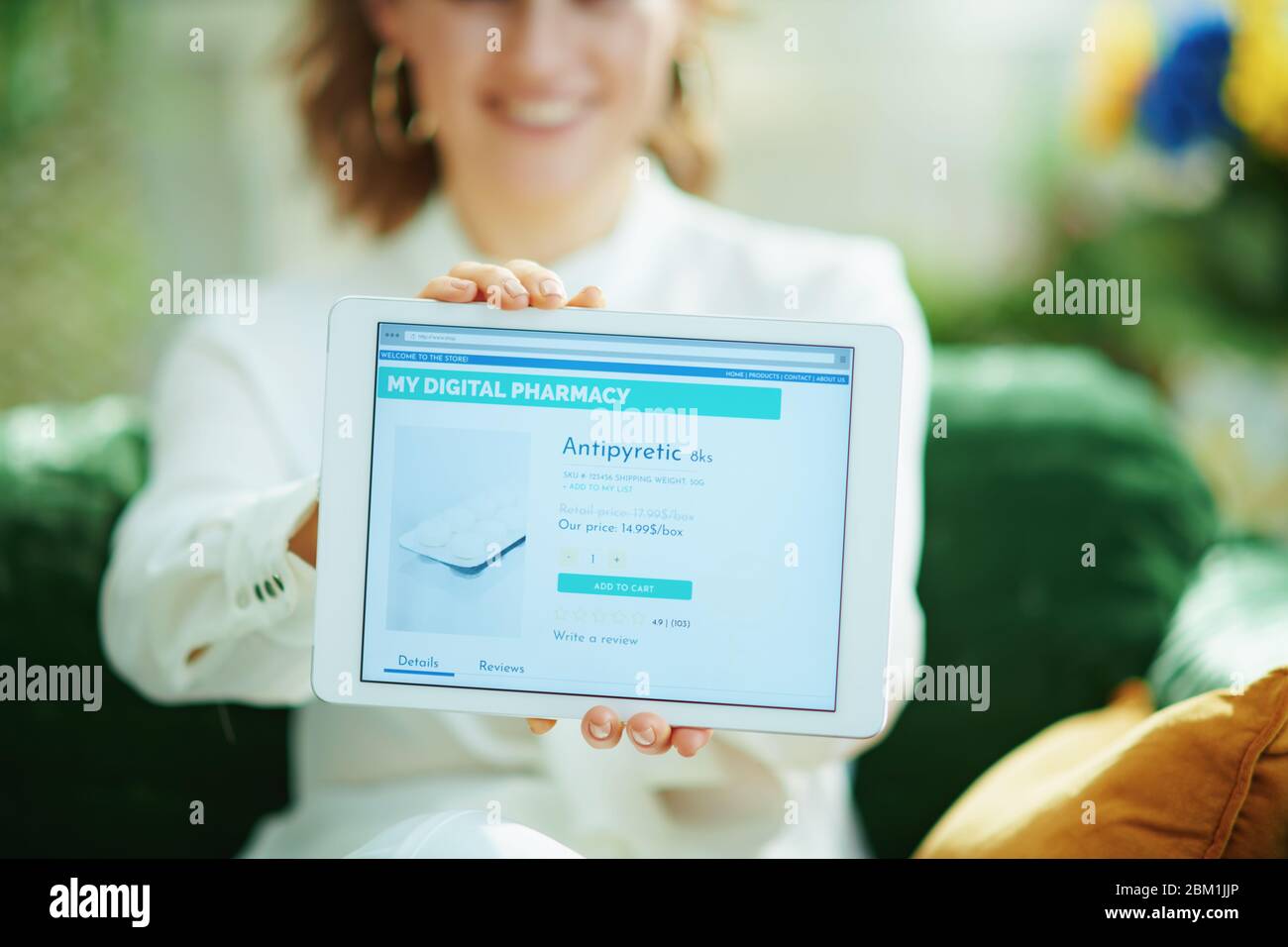 Closeup on woman at home in sunny day showing online pharmacy store on ...