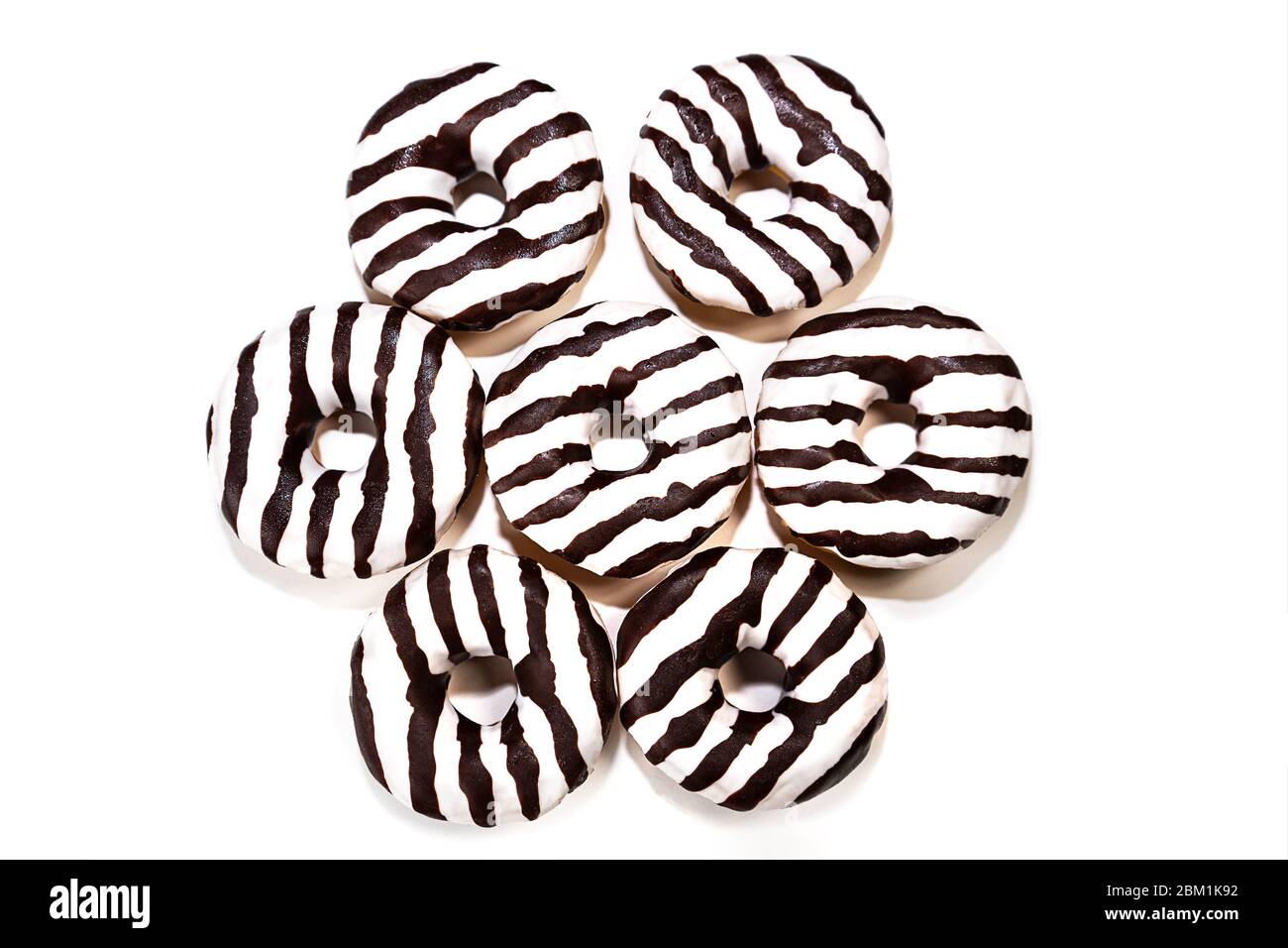 Glazed striped donuts on white background, isolated. Party food concept ...