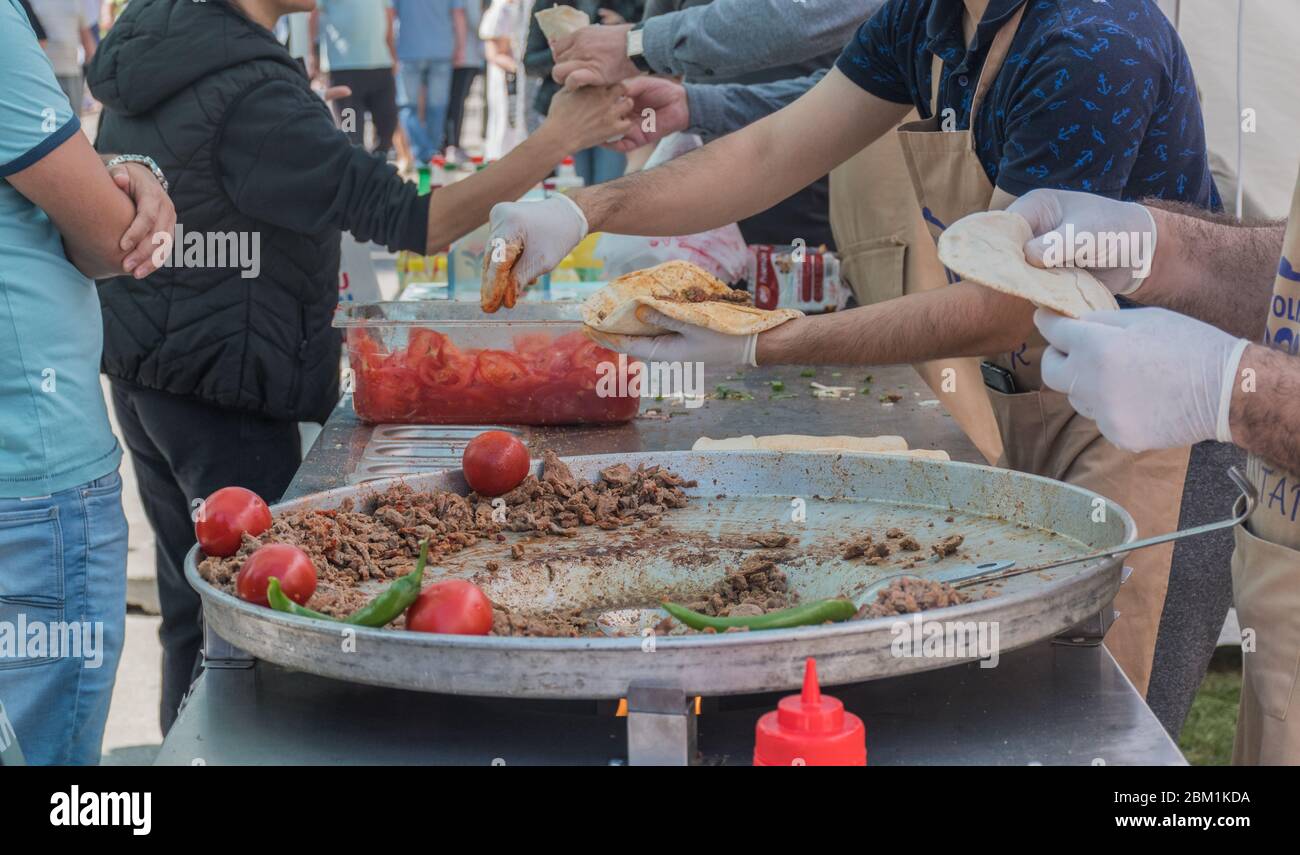 Traditional Turkish shawarma meat being prepared with red tomatoes and ...