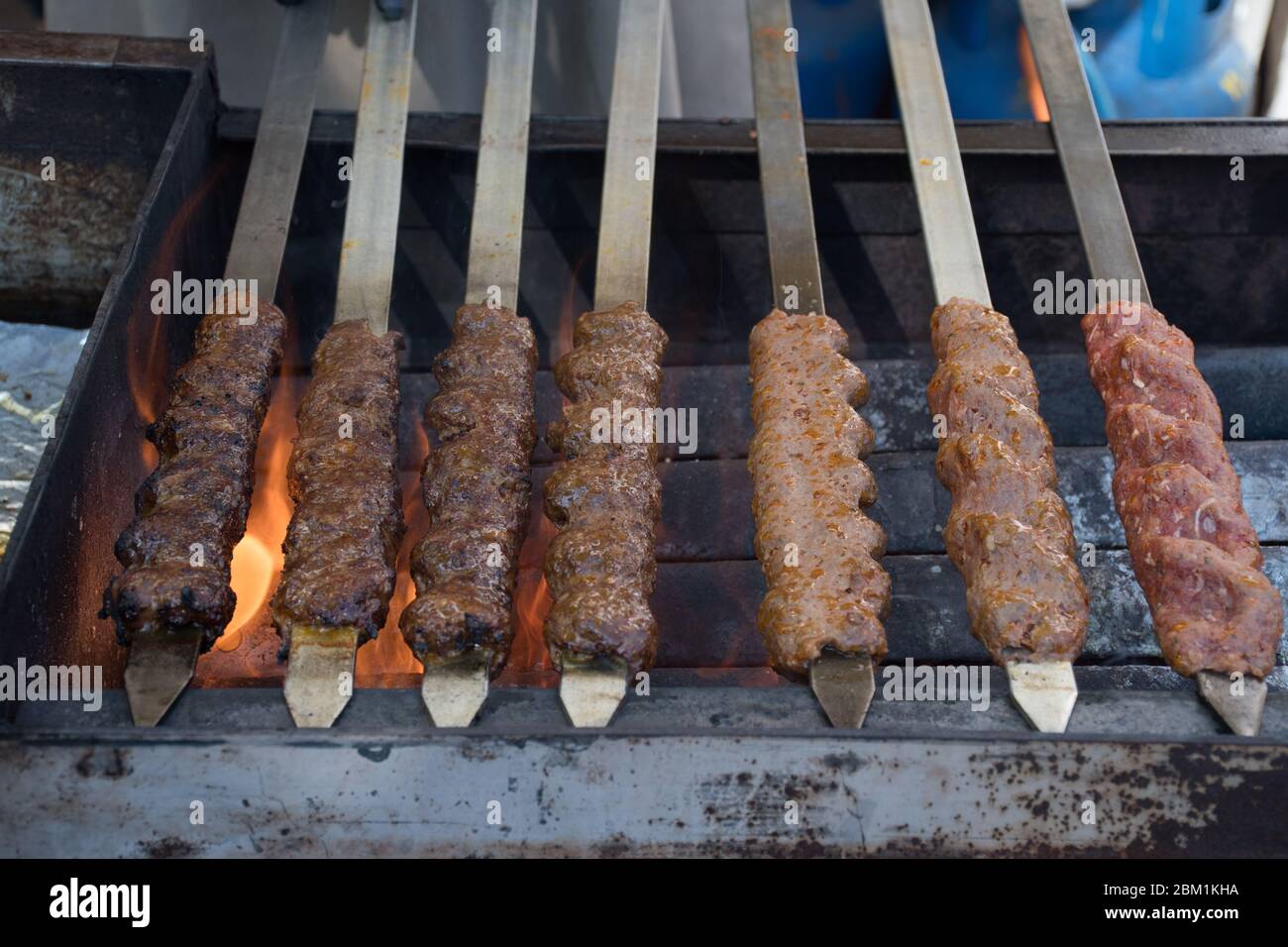 Adana kebab (ground lamb minced meat on skewer on grill over charcoal ...