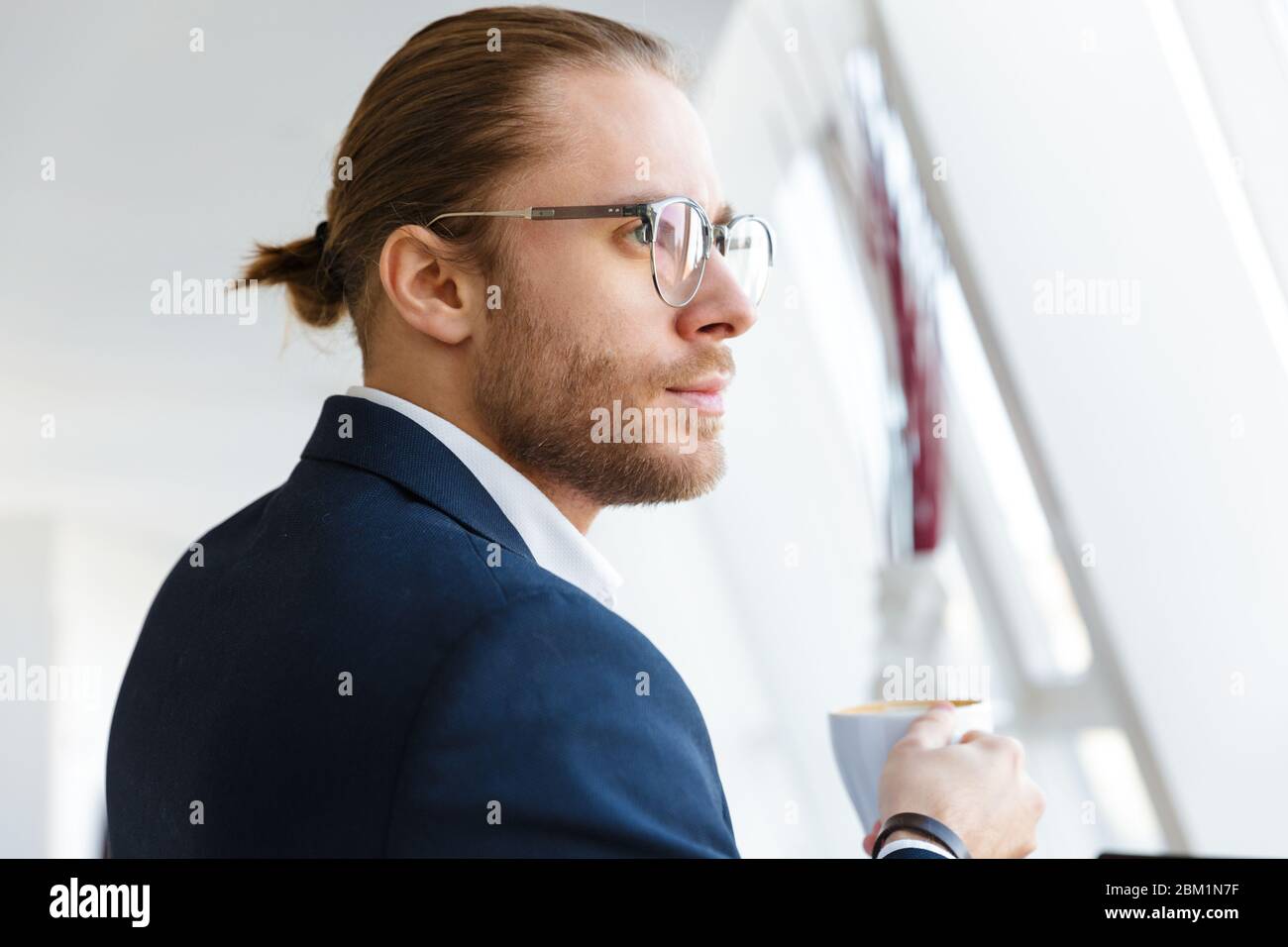 Image of attractive concentrated young businessman indoors in office ...