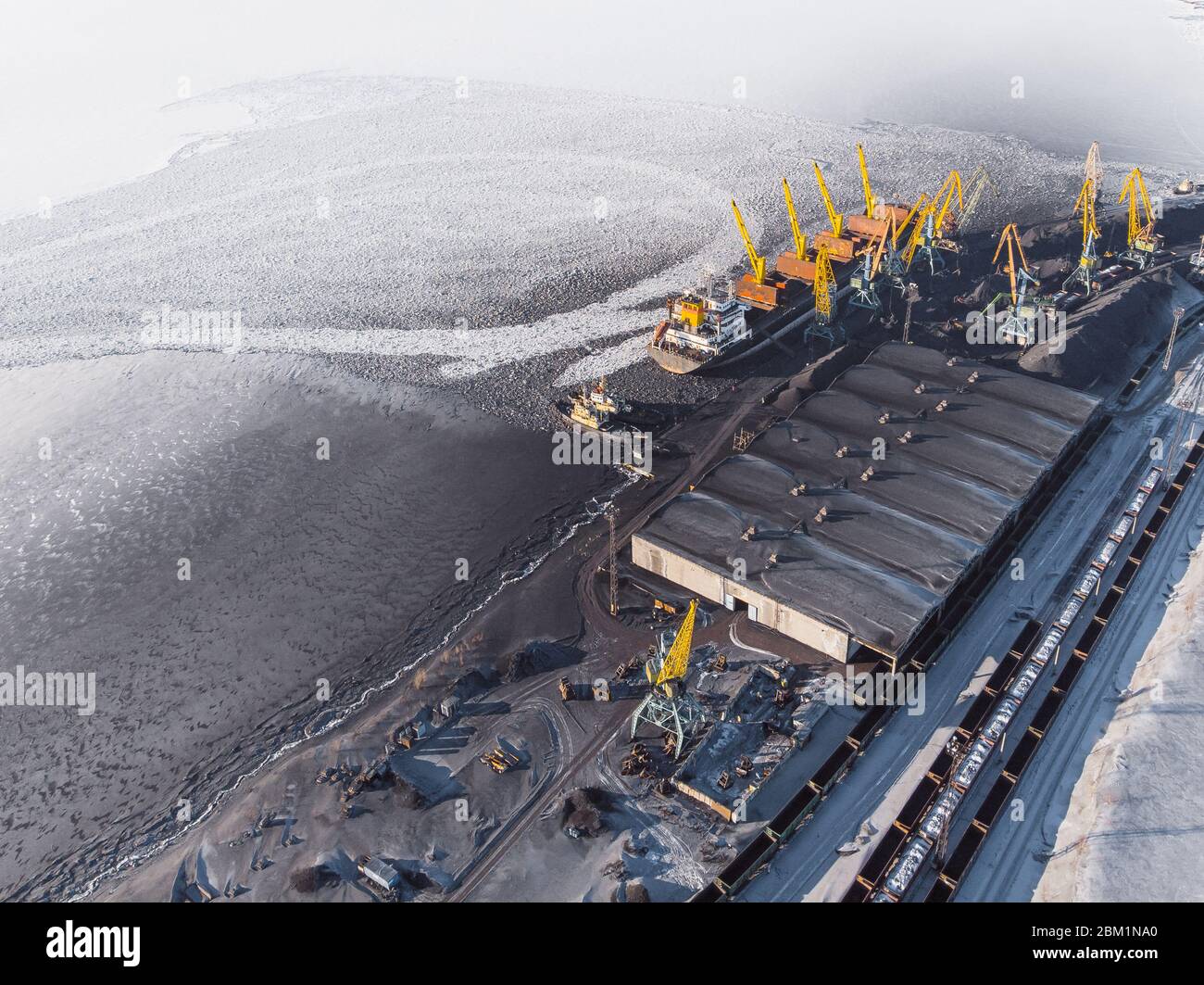 Loading coal mining in port on cargo tanker ship with crane bucket of ...