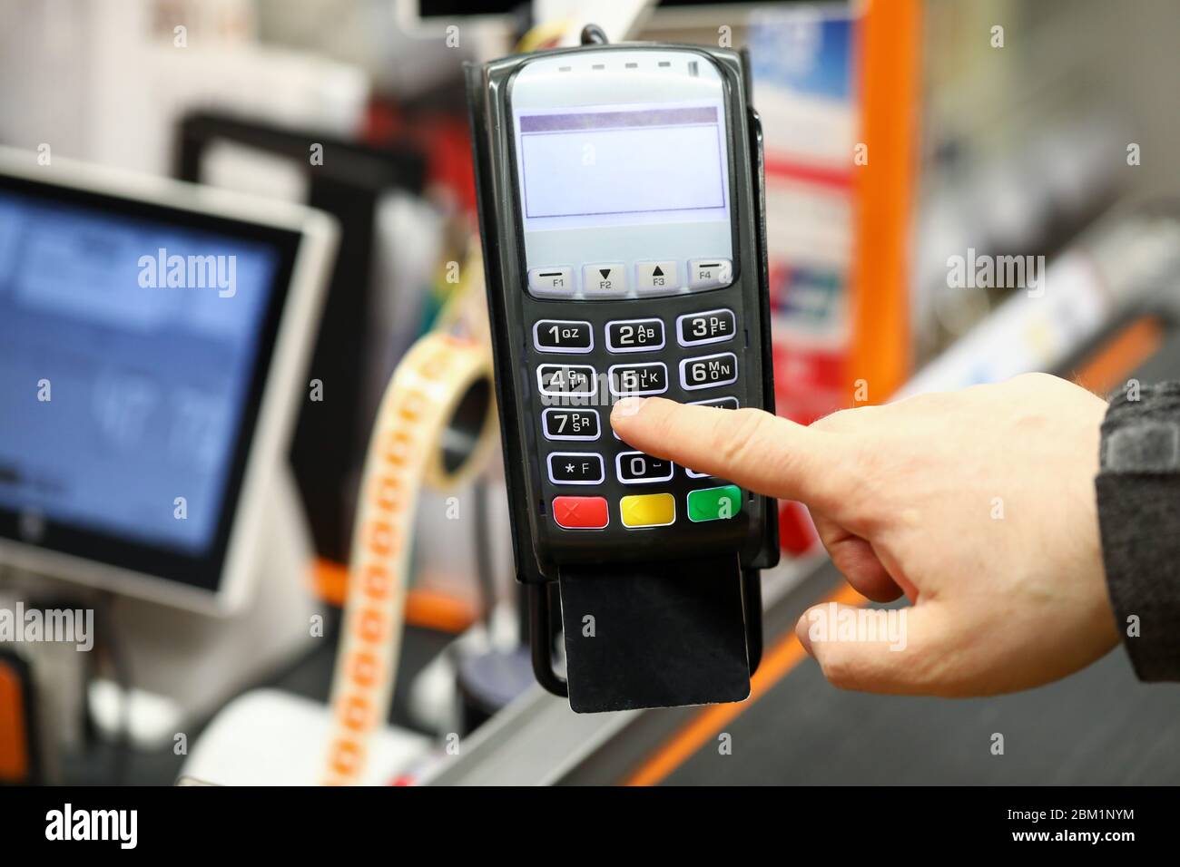 Male hand typing pin code card while paying with it at cash desk of ...