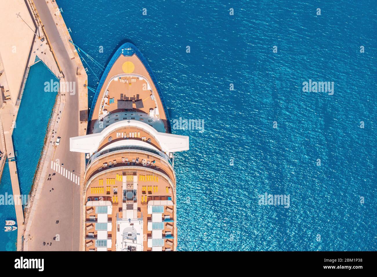 Cruise liner luxury ship in berth in port, blue sea water. Top aerial ...