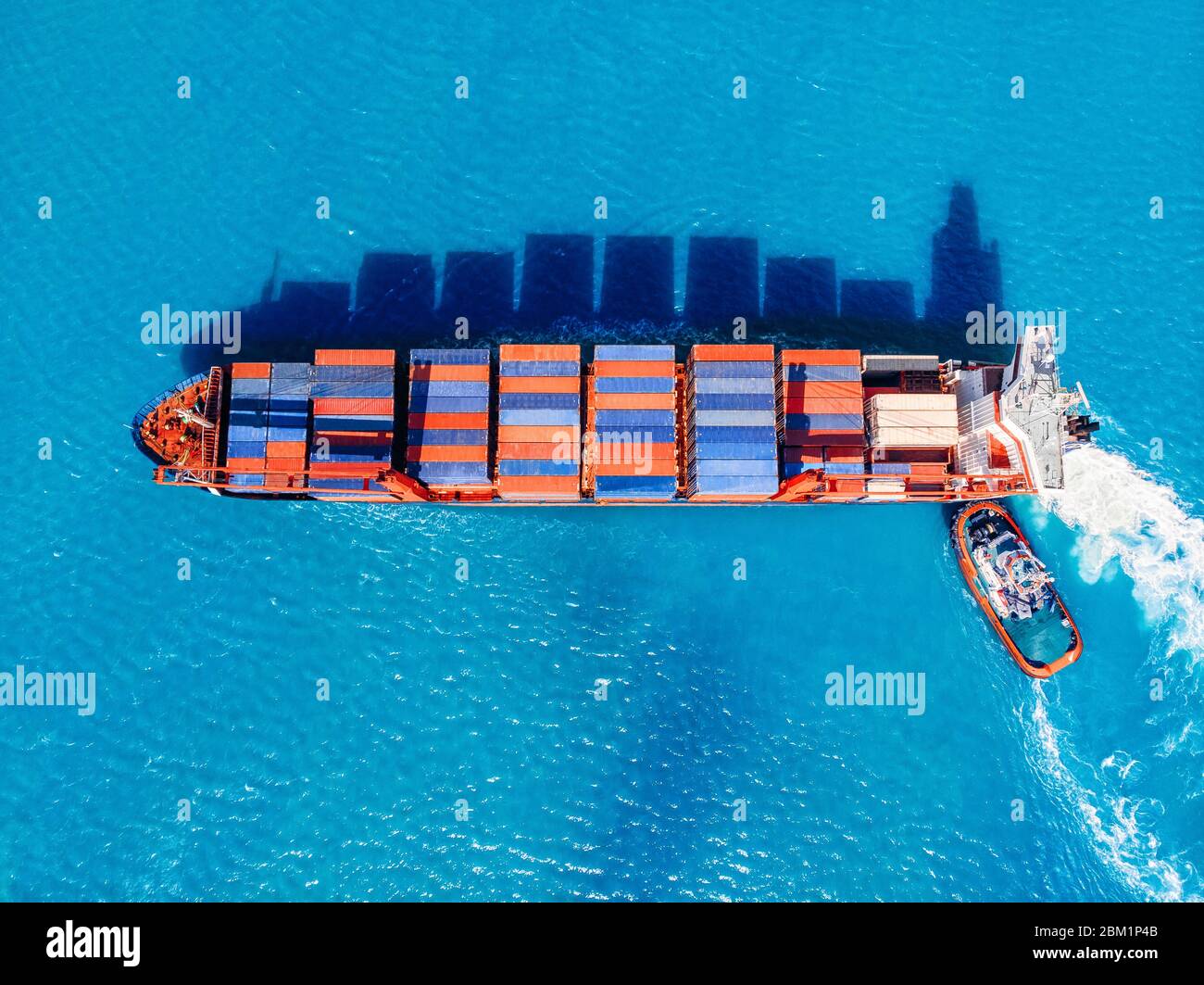 Cargo ship enters trading port, tug helps moor to pier. Logistics ...