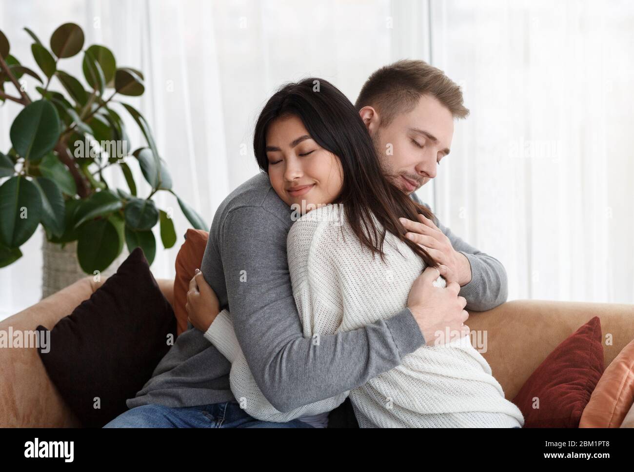 Multicultural Couple Hugging Reconciling After Quarrel At Home Stock ...