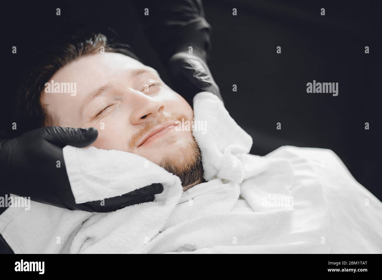 Barber steam face skin of man with hot towel before royal shave in ...