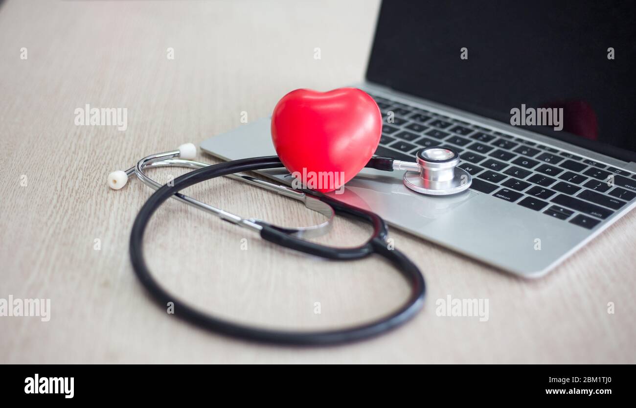 Stethoscope, mini hearth and laptop or computer on doctor desk prepare ...