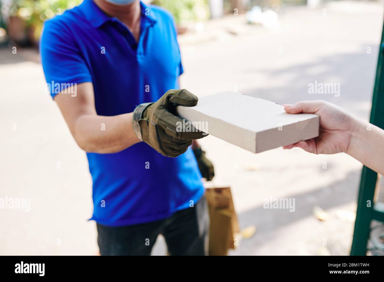 Close-up image of courier giving small cardboard box to customer Stock ...