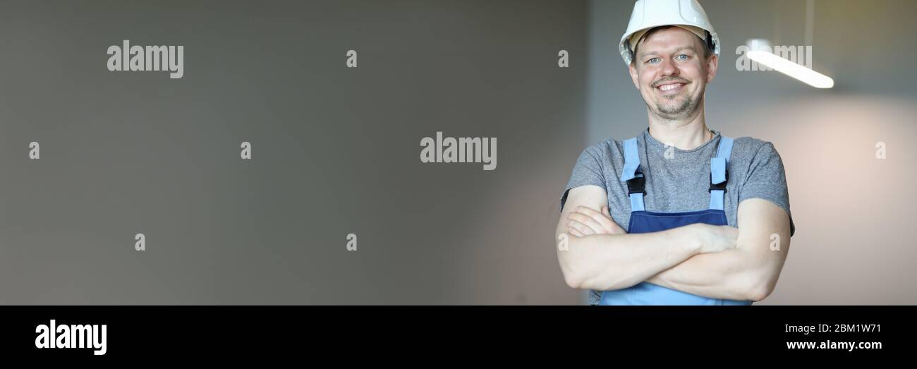 Happy man in work clothes folded arms over chest Stock Photo - Alamy