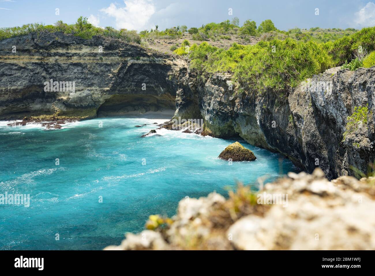 (Selective focus) Stunning view of a rocky cliff bathed by a turquoise ...