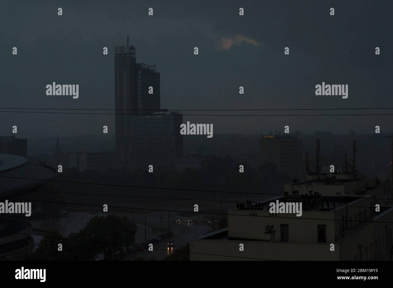 barely visible skyscrapers, street with cars, houses during a storm and ...
