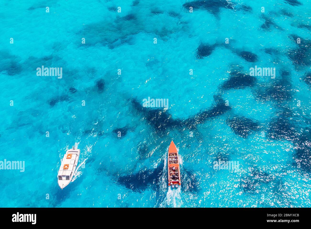 Pleasure Speedboat sailing on blue clear water of large coral reef with ...