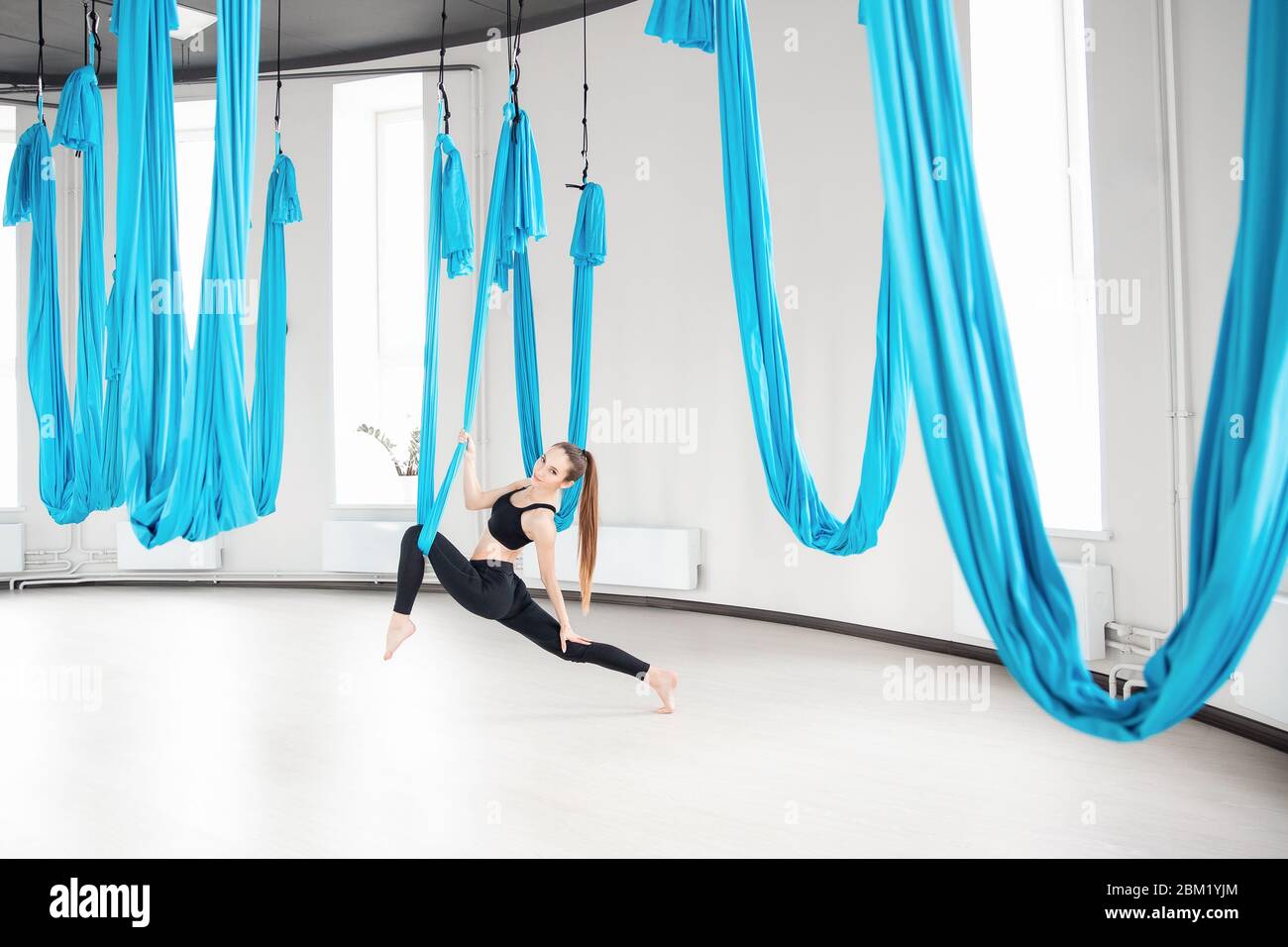 Young beautiful women practicing aerial yoga stretching in gym Stock ...