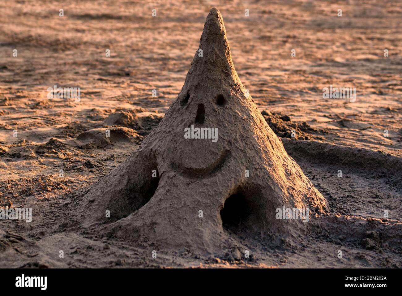 View of beach with little sand figures near sea on sunny summer day ...