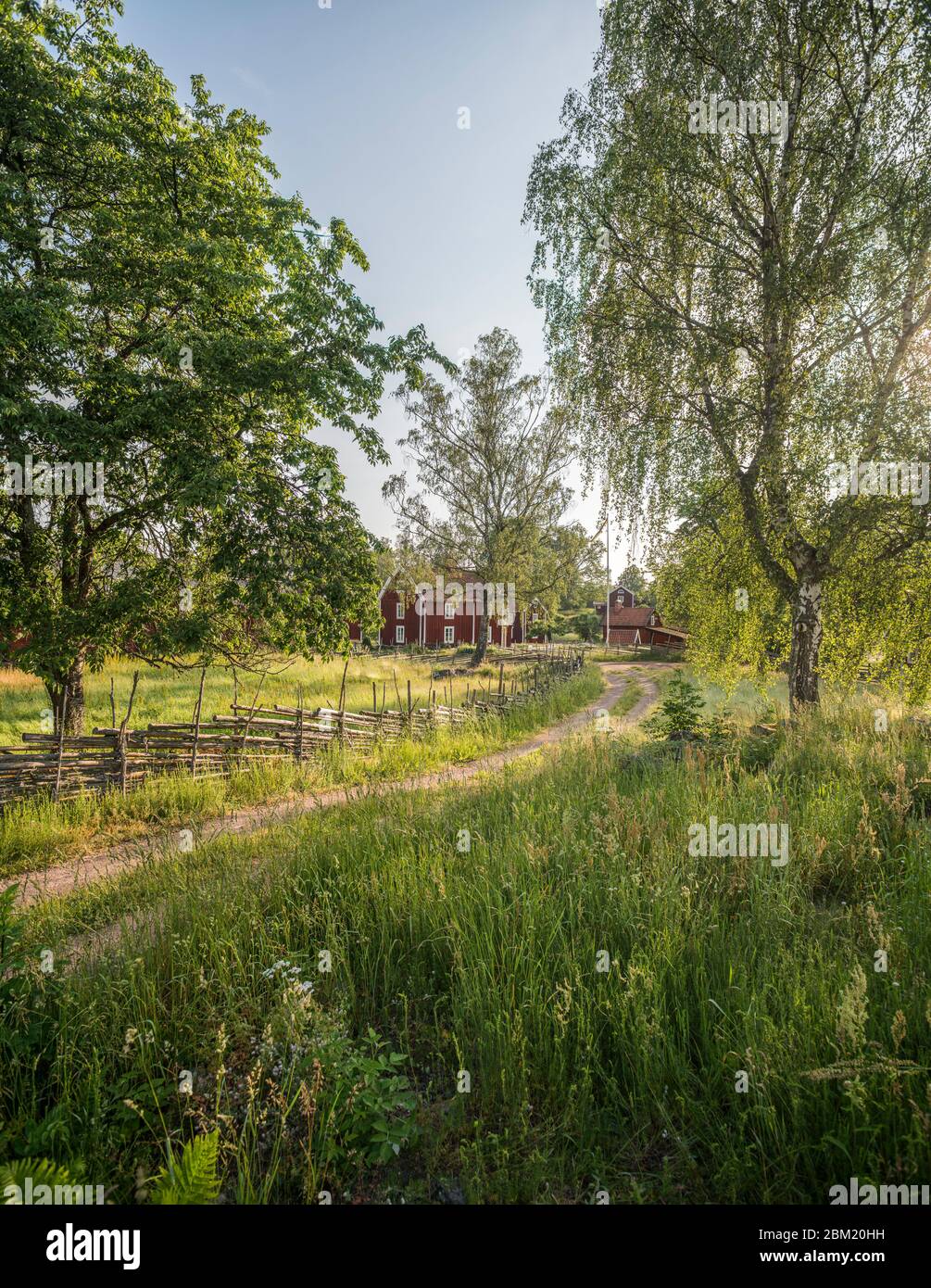 Small country road and old traditional red cottages in a rural ...