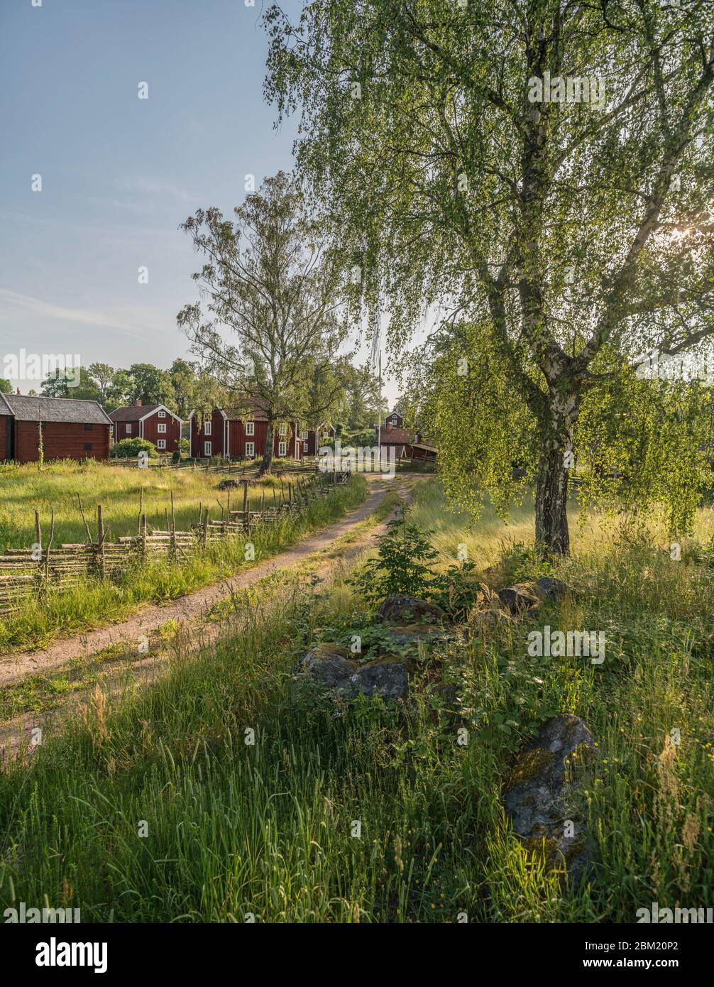 Small country road and old traditional red cottages in a rural ...