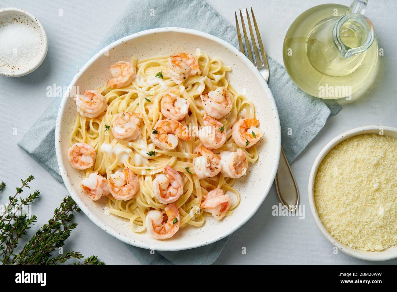 Pasta bavette with fried shrimps, bechamel sauce, thyme on blue table ...