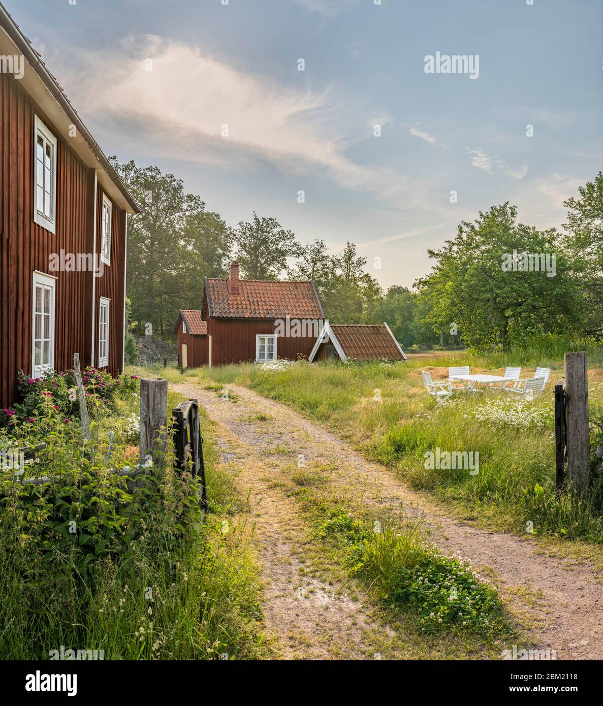 Small country road and old traditional red cottages in a rural ...