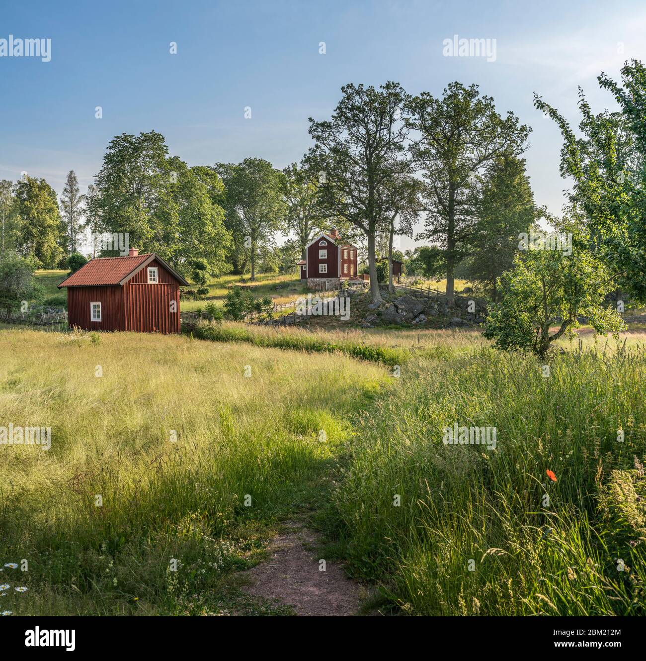 Small country road and old traditional red cottages in a rural ...