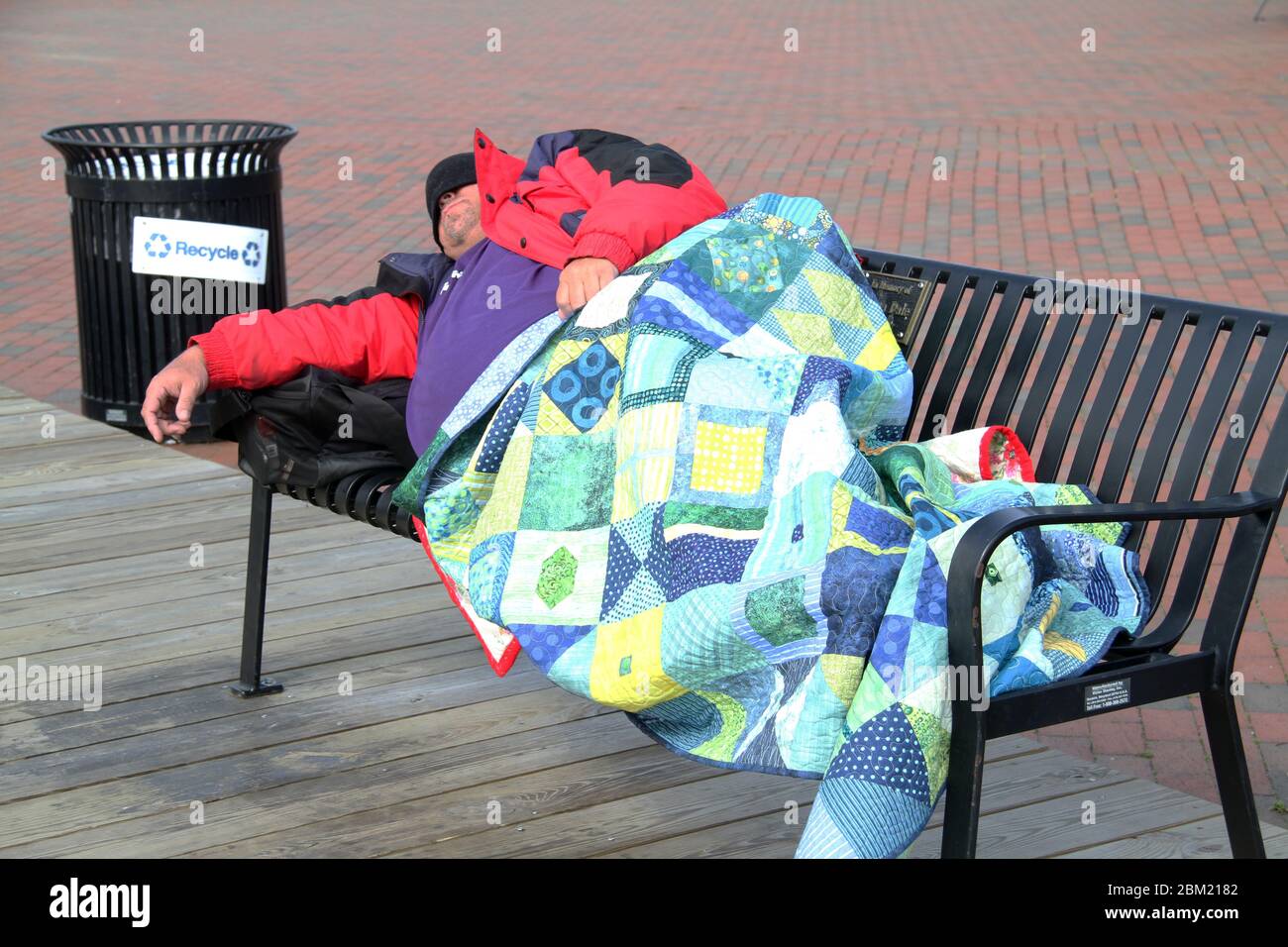 Homeless man sleeping on a public bench in the city Stock Photo - Alamy