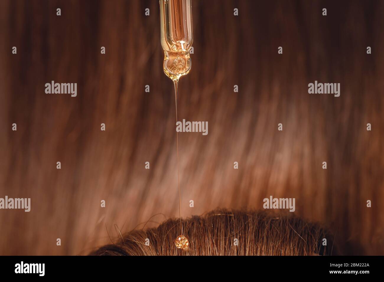 Close-up drop oil restore and recovery hair is applied to head bulbs ...