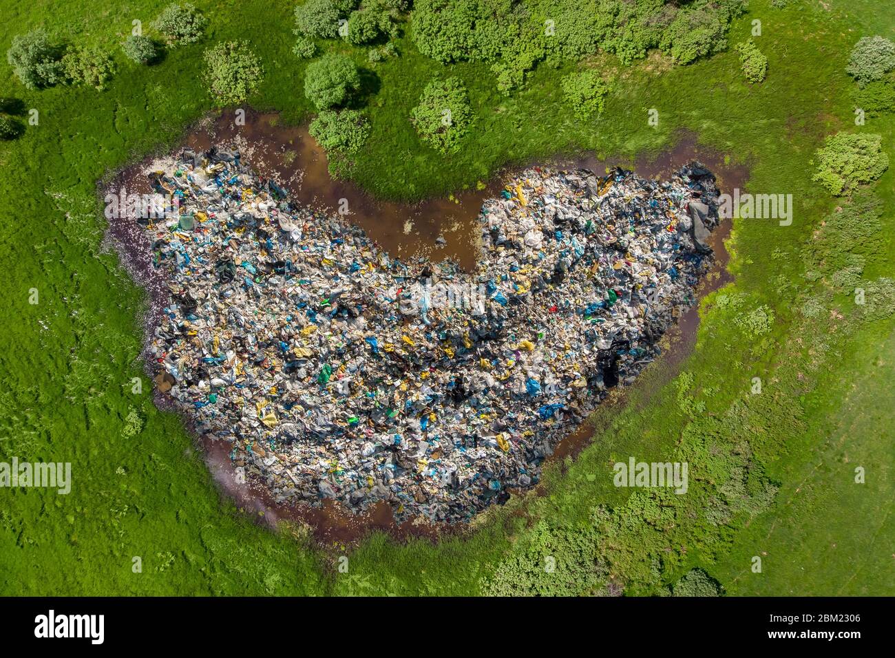 Trash waste plastic and packages on clean green field. Concept ...