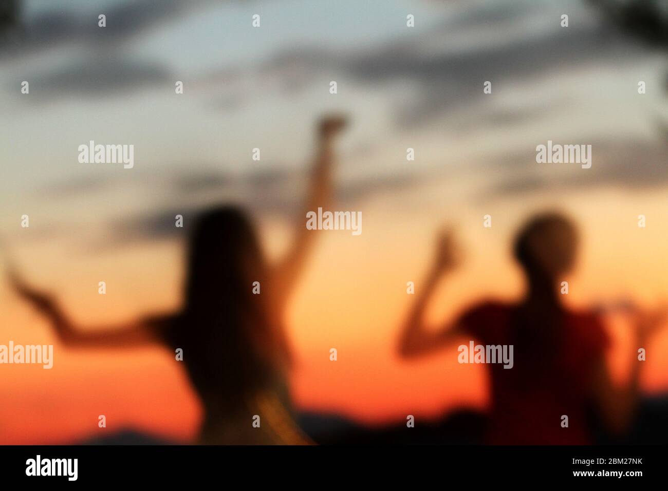 Silhouettes of young people seen dancing against an evening sky Stock ...