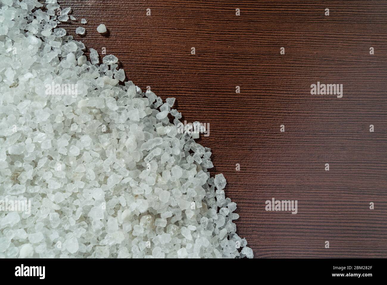 white crystalline salt sprinkled on a brown table Stock Photo - Alamy