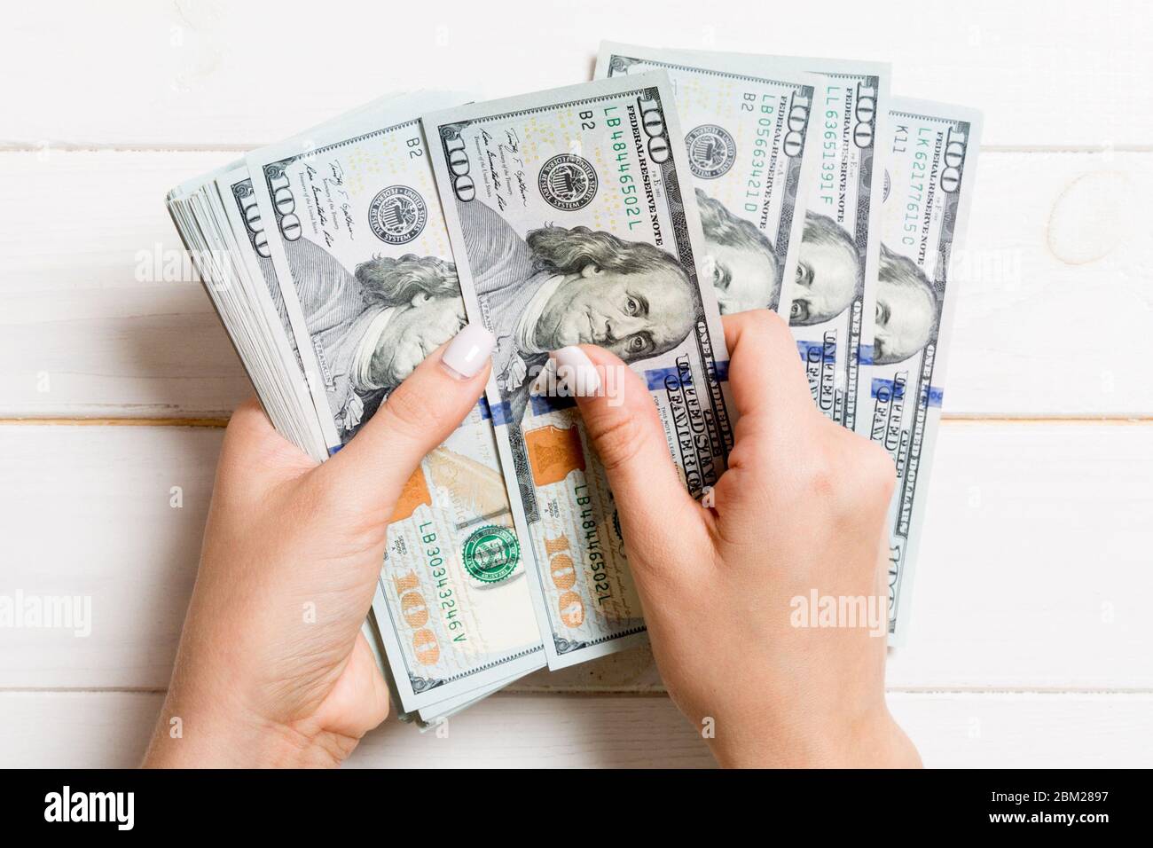 Top view of female hands counting money. One hundred dollar banknotes ...