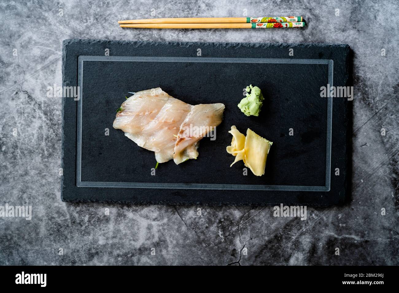 Suzuki Fish Sashimi with Pickled Ginger and Wasabi on Black Stone Board ...