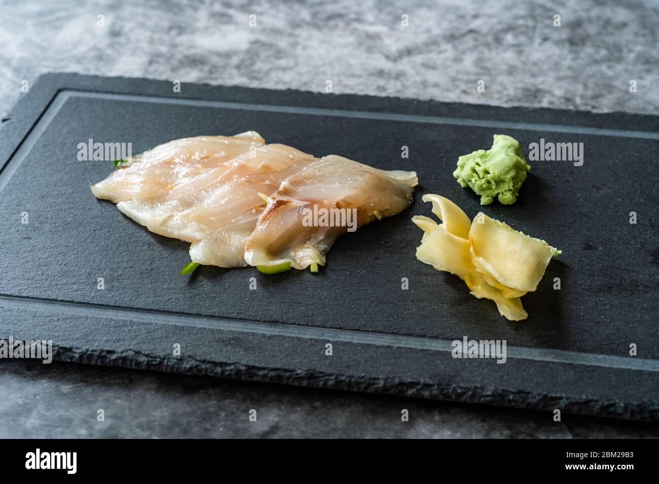 Suzuki Fish Sashimi with Pickled Ginger and Wasabi on Black Stone Board ...