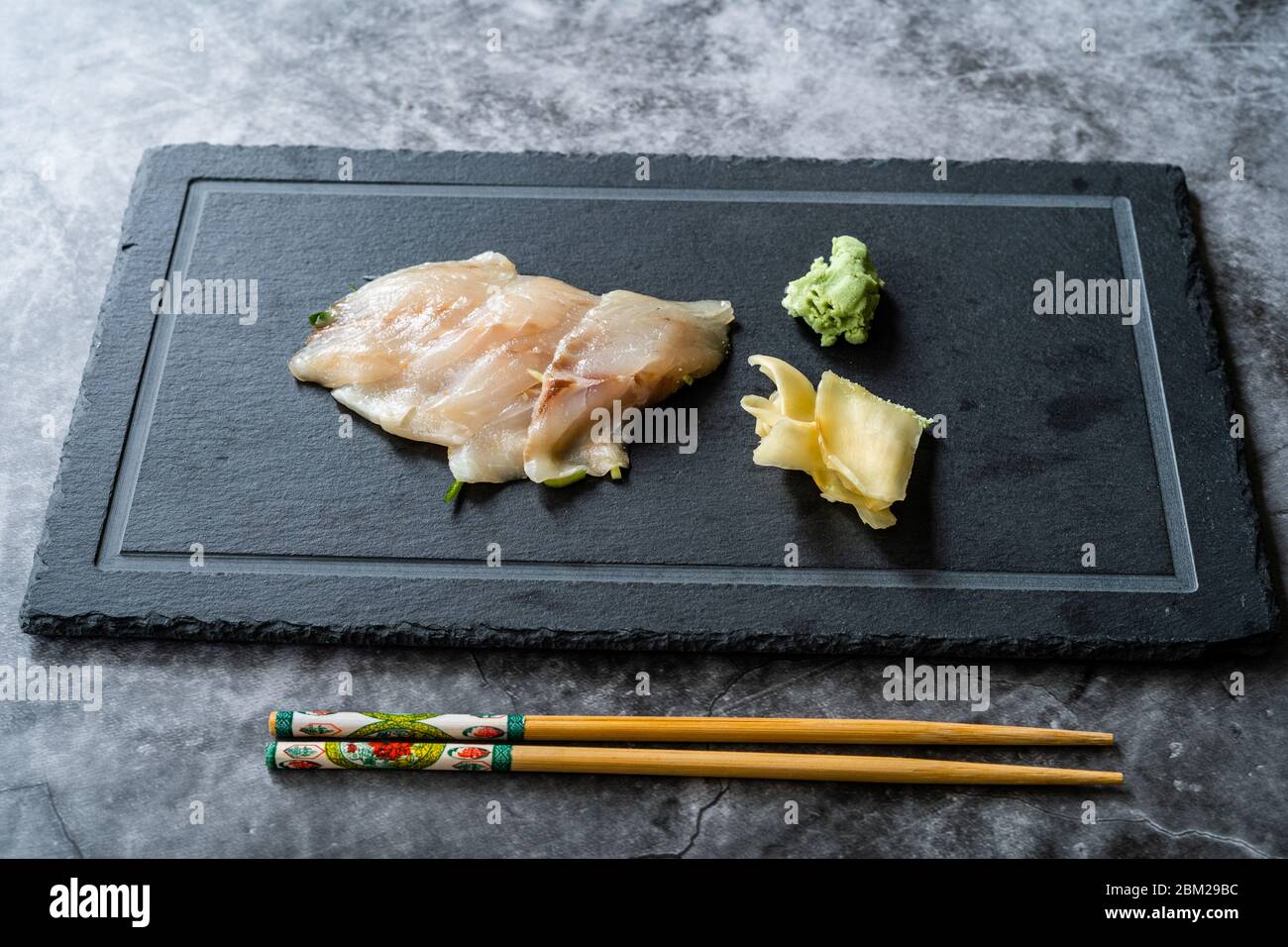 Suzuki Fish Sashimi with Pickled Ginger and Wasabi on Black Stone Board ...