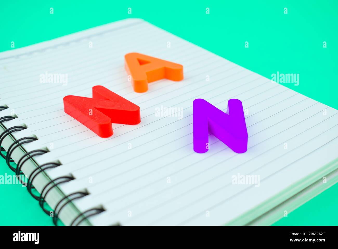 Three different colored letter blocks placed on a white isolated note ...
