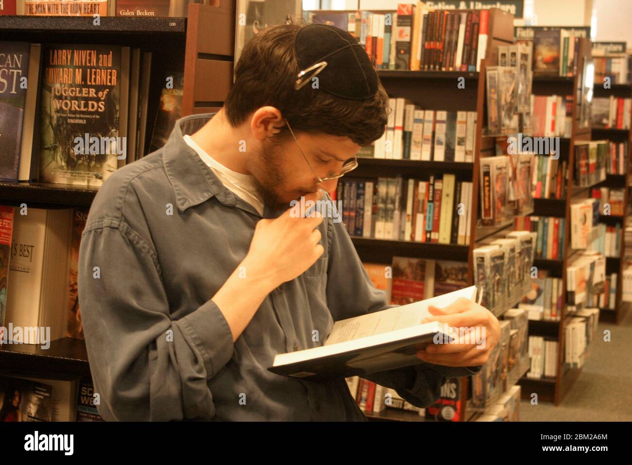 Young Jewish man reading a book inside a book store in New York City ...