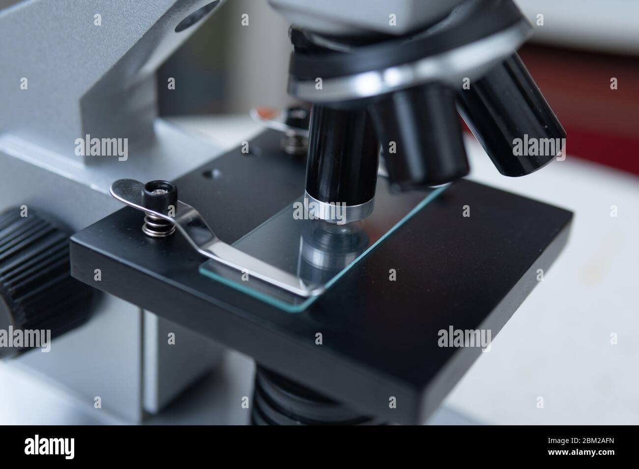 Microscope on white and red background close frame Stock Photo - Alamy